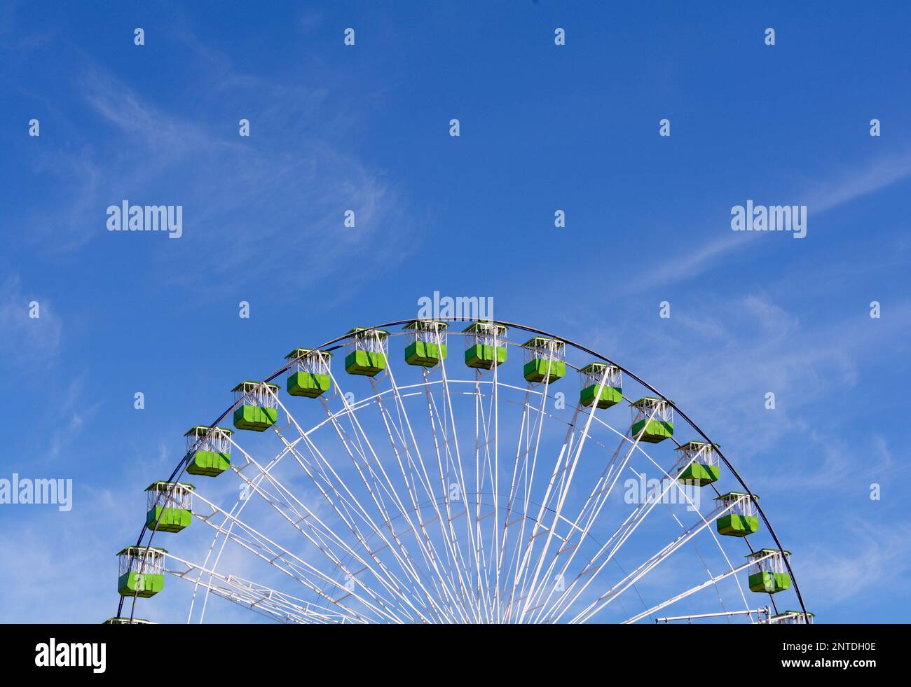 An old green ferris wheel set against a clear blue sky Stock Photo - Alamy