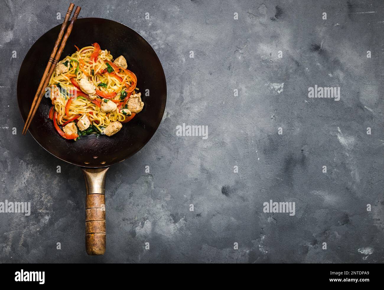 Stir fry noodles in traditional Chinese wok, chopsticks, ingredients ...