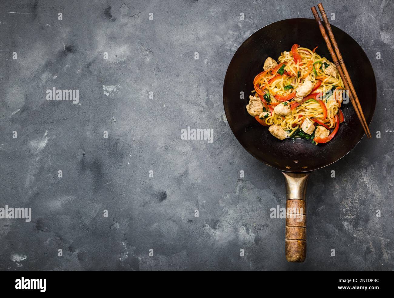 Stir fry noodles in traditional Chinese wok, chopsticks, ingredients ...