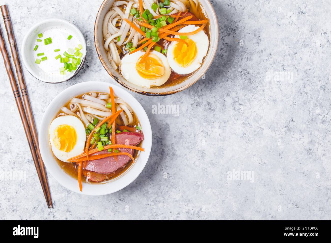 Bowls with Japanese soup ramen, chopsticks, white concrete rustic ...