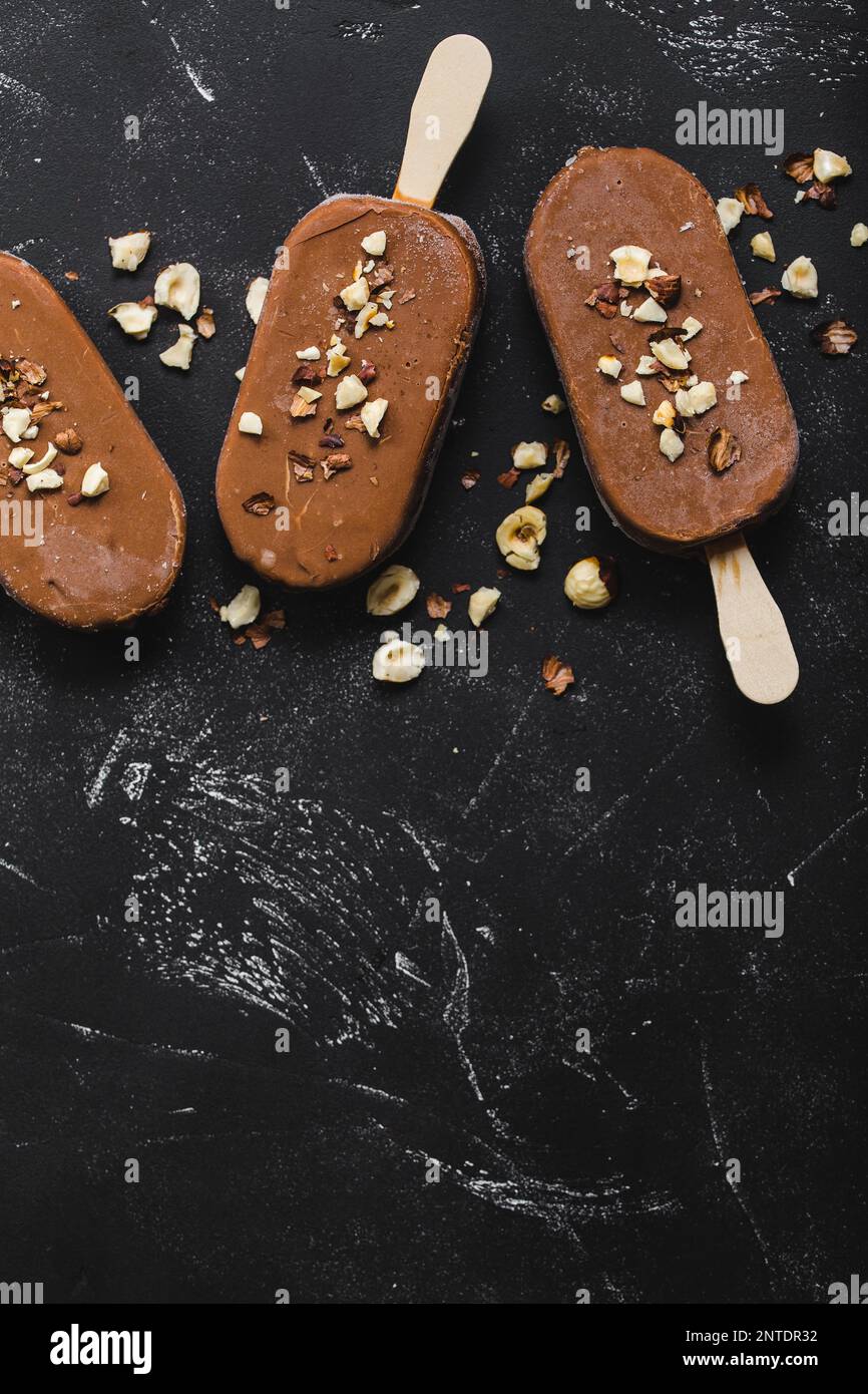 Milk chocolate popsicles with hazelnuts. Close-up. Ice cream popsicles ...