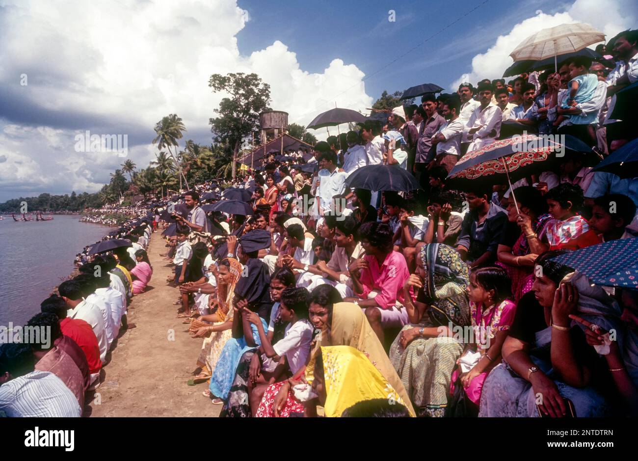 Boat racing spectators seated on the banks of Pamba river in Aranmula ...
