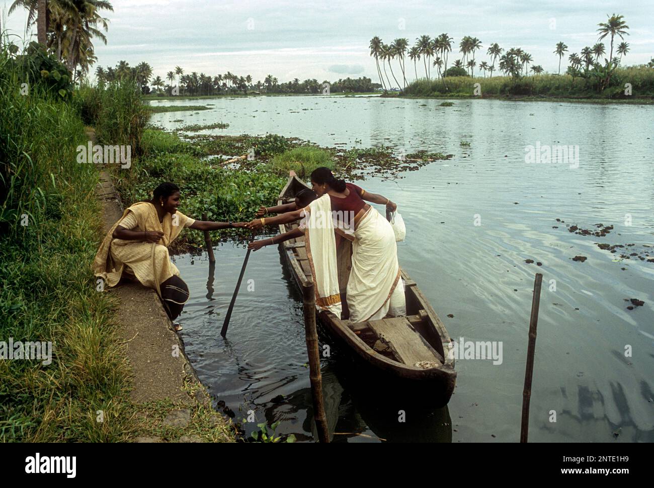 A woman helping another woman to get down from the boat, Backwaters of ...