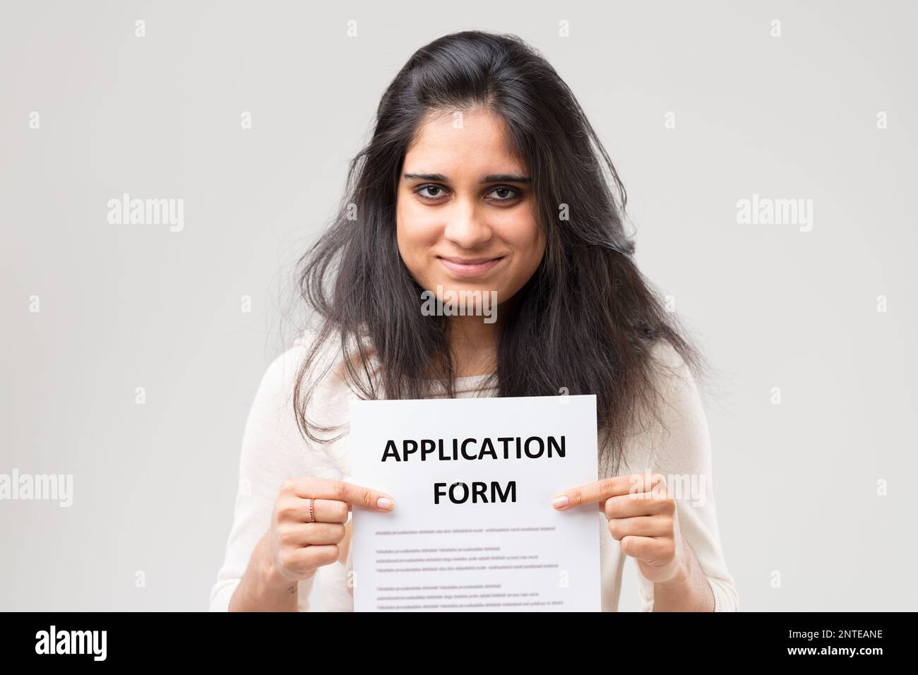 Horizontal half-length portrait of young Indian woman holding a sign ...