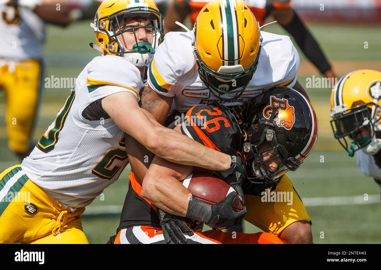 B.C. Lions Jamel Lyles (26) is tackled by Edmonton Eskimos Josh Johnson ...