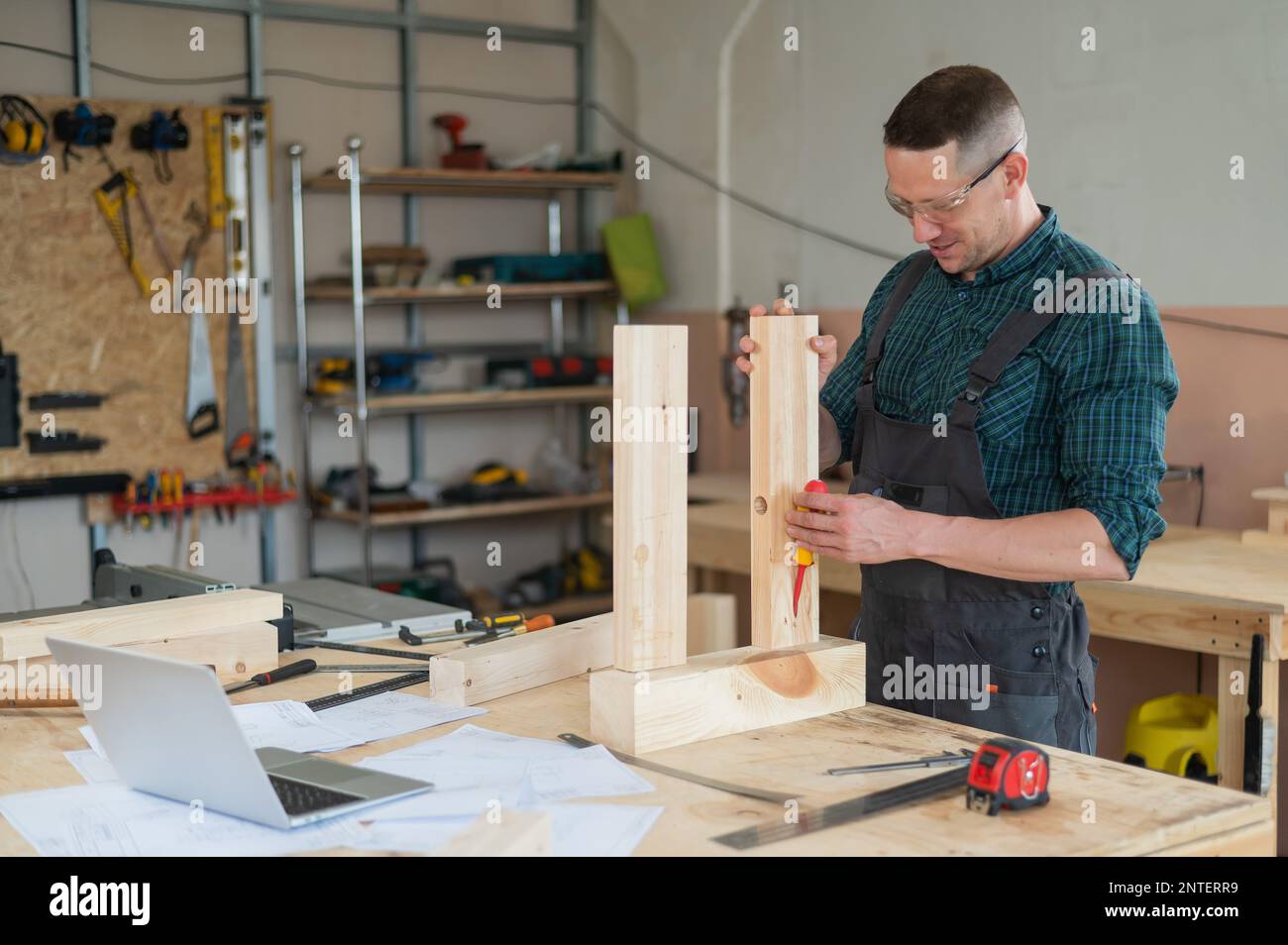 Caucasian man assembling a table with a screwdriver Stock Photo - Alamy