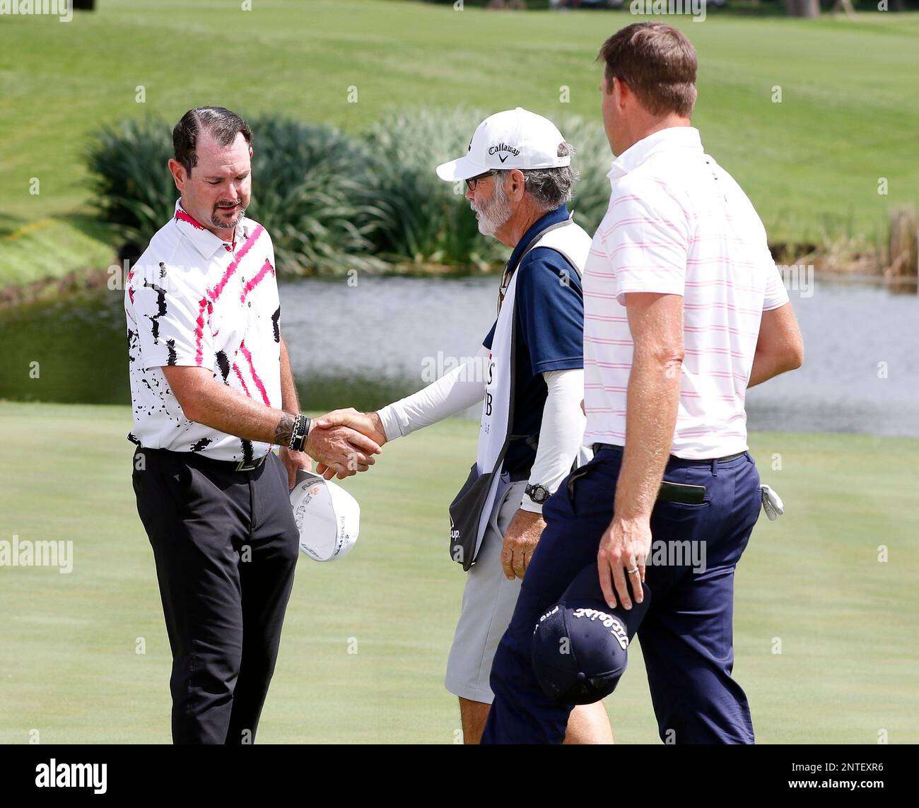 Rory Sabbatini shakes the hand of Nick Watney's caddie Tony Navarro ...