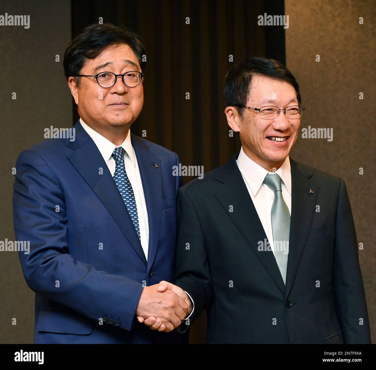 Mitsubishi Motors Corporation (MMC) CEO Osamu Masuko (L) shakes hands ...