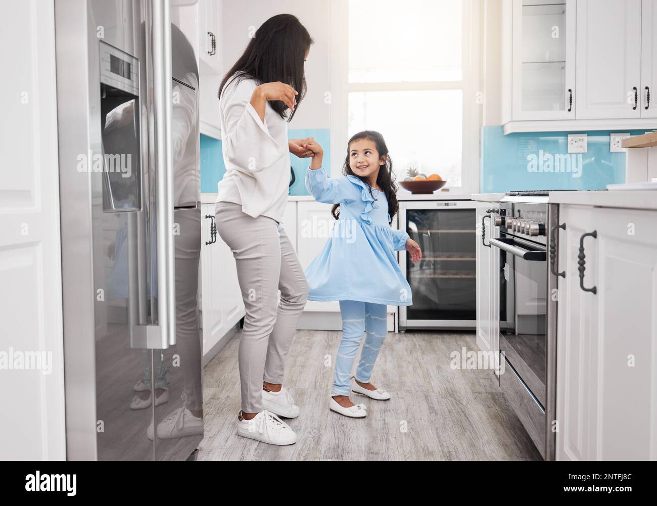 Mother, dancing and girl in the kitchen with bonding, parent care and ...