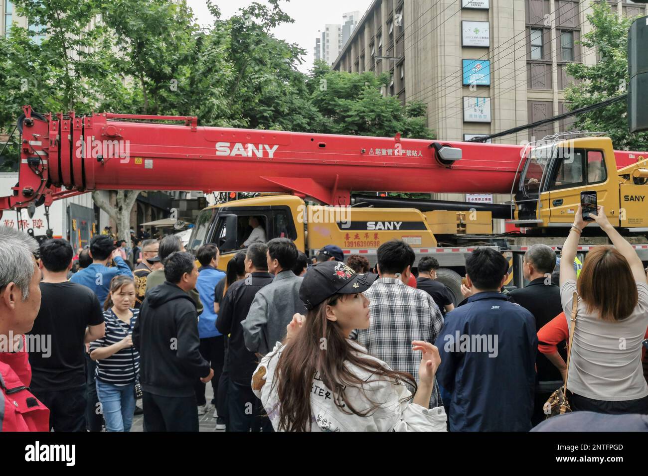 Residents look on as a heavy lift vehicle arrive near the site of a ...