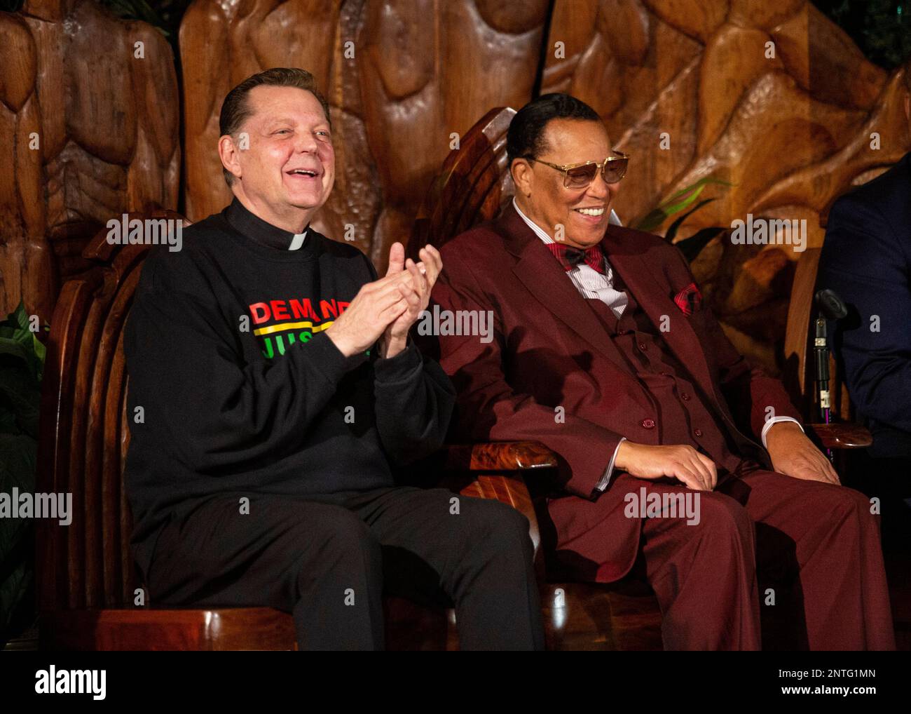 Father Michael Pfleger sits next to Minister Louis Farrakhan, of the ...