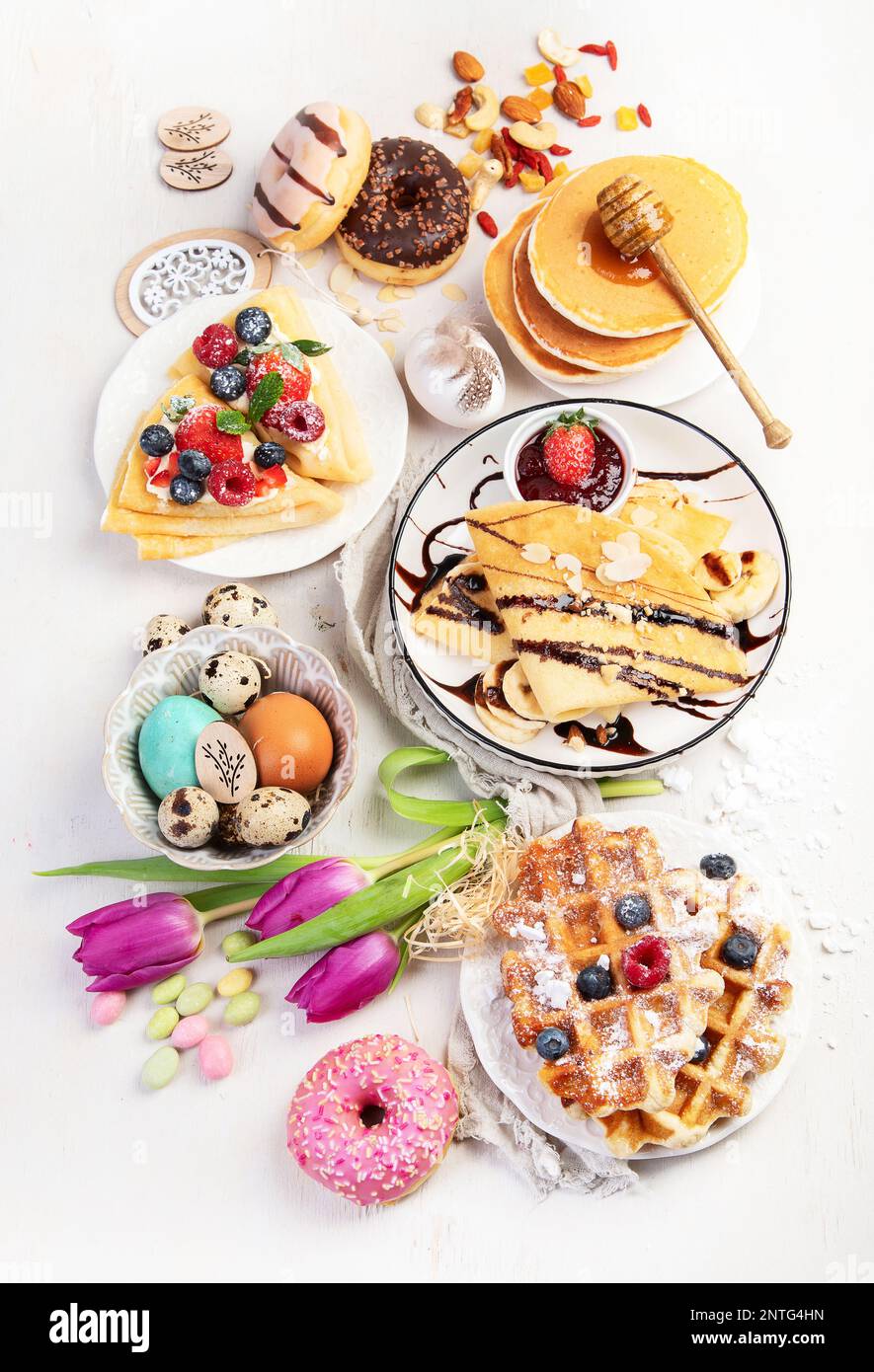 Easter sweet dessert table. Pancakes, crepes, waffles and donuts with ...