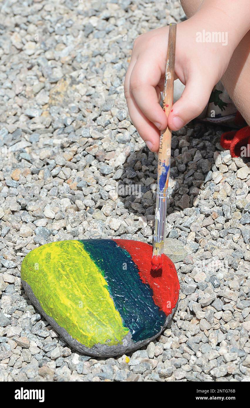 A student paints a rock at the Roxaboxen Park as part of the DIY Murals ...