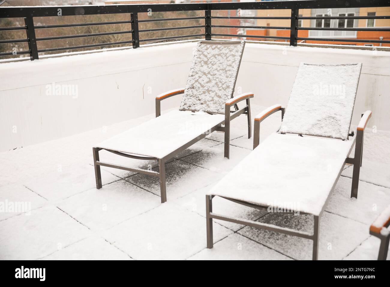 snow on benches tables and chairs outside during winter time covered by ...