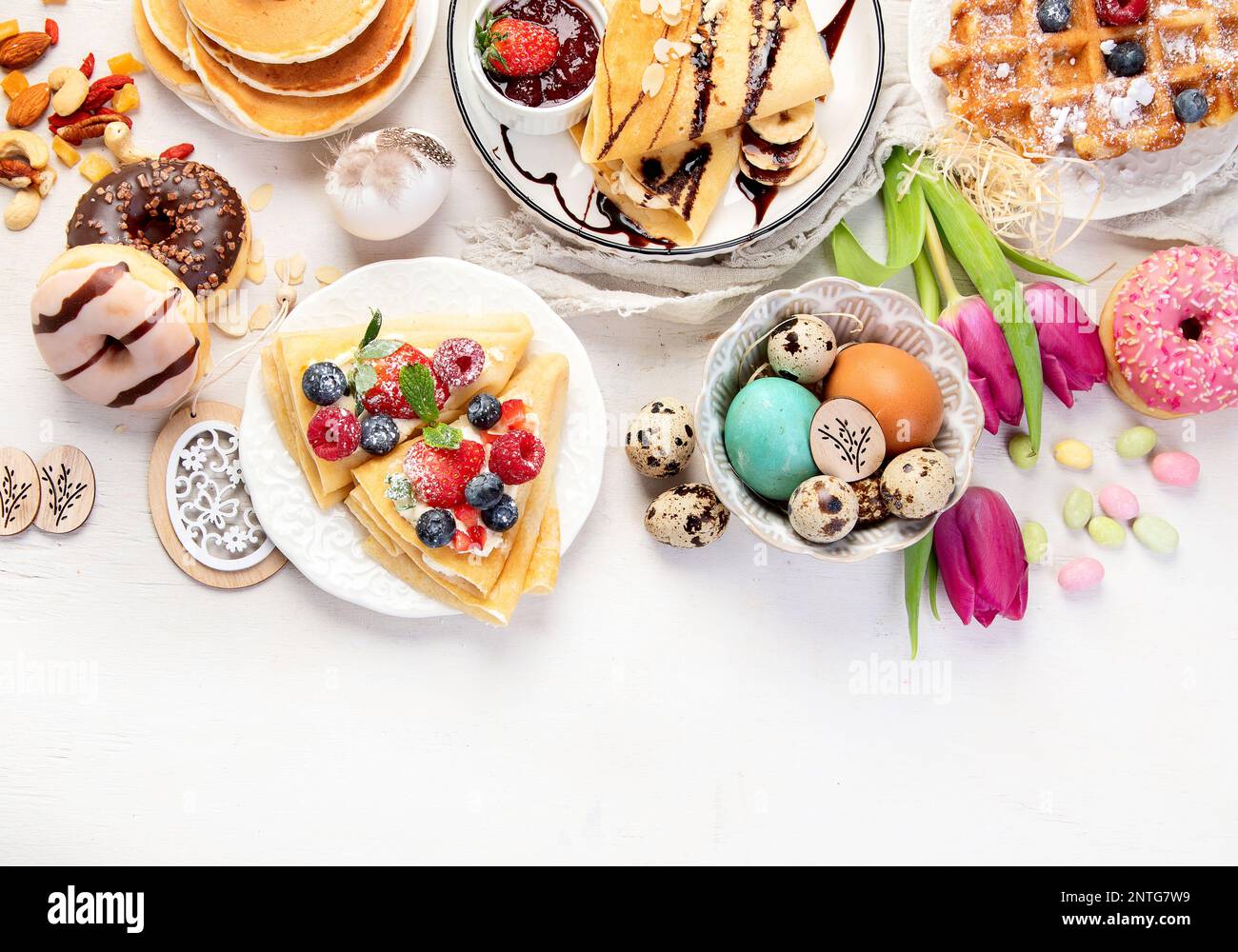Easter sweet dessert table. Pancakes, crepes, waffles and donuts with ...