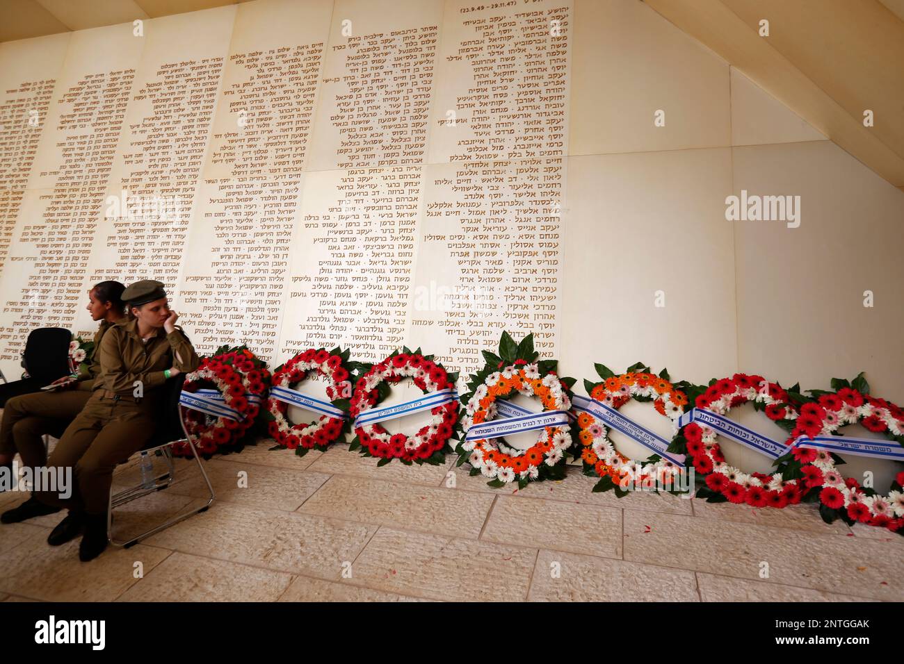 Israeli soldiers sit next to a monument engraved with names of fallen ...