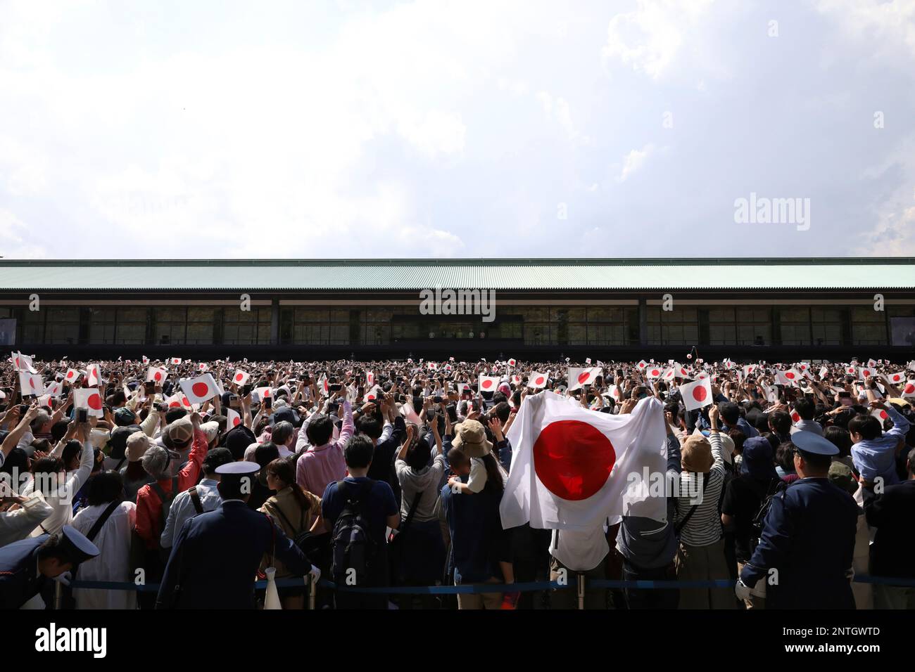 Well-wishers wave Japan's national flag during Japan's new Emperor ...