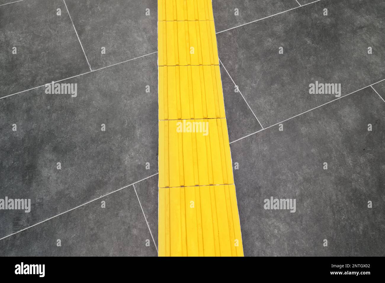 Footpath or yellow tactile tiles for the blind in building space, top ...