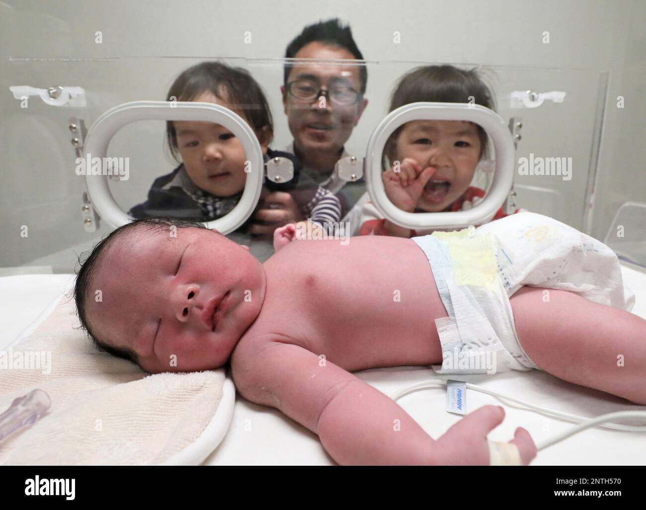 Kimisuke Ozaki, together with his children looks at a new born baby on ...