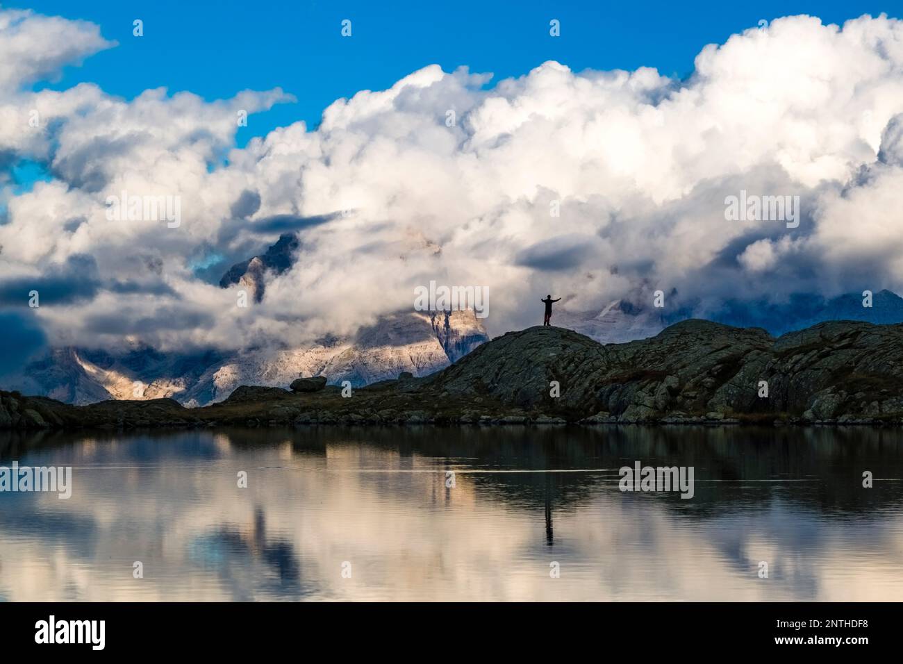 A man standing on a rocky ridge at the lake Lago Nero, the main range ...