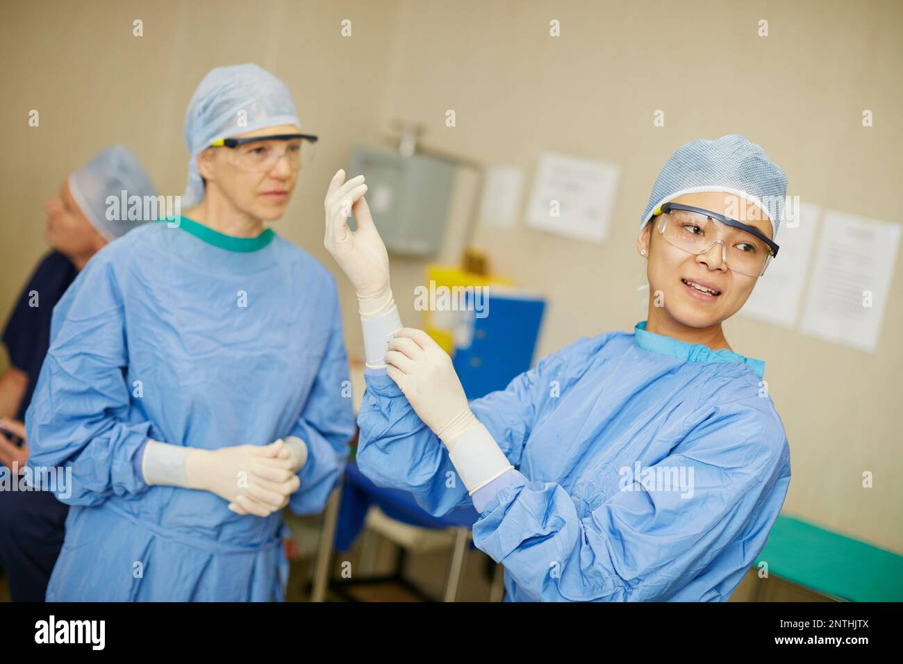 Ready to save lives. surgeons putting on surgical gloves in preparation ...