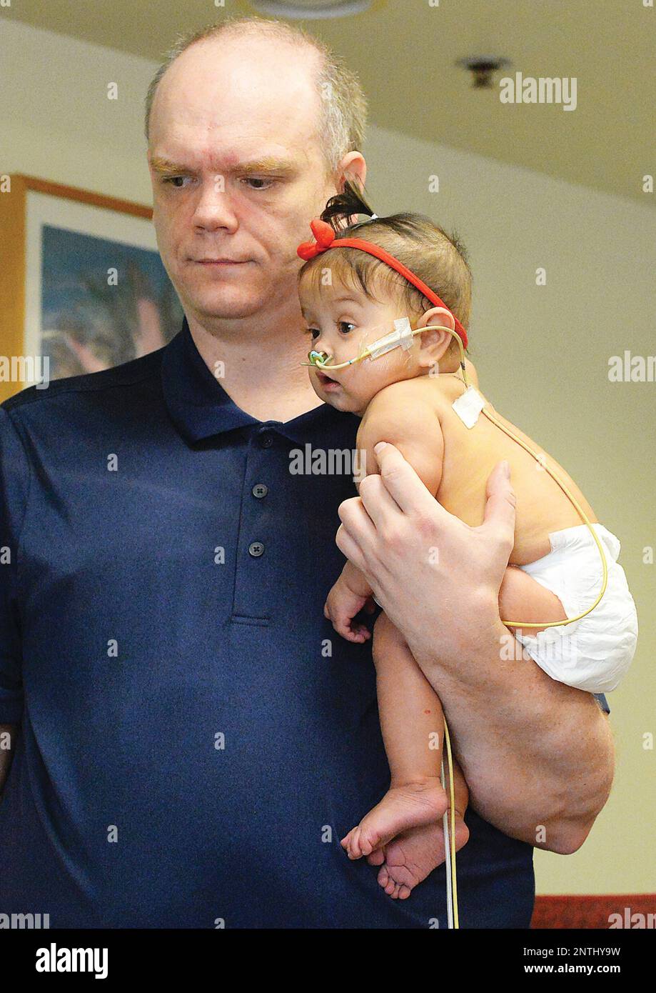 Sheldon Adams, left, holds his nine-month-old daughter Alice Adams ...