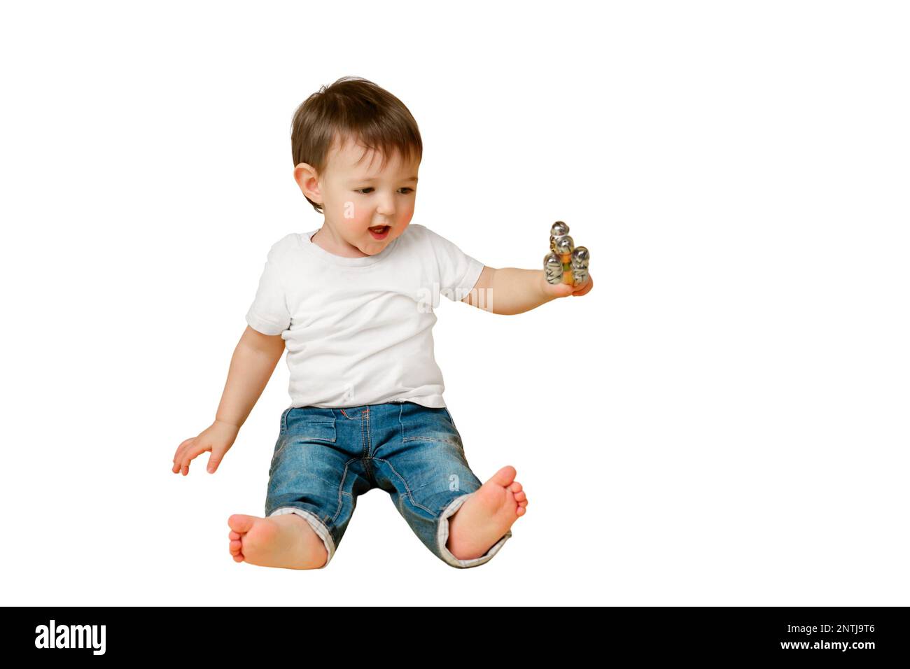 Toddler baby plays with a musical rattle bells on a stick, studio ...