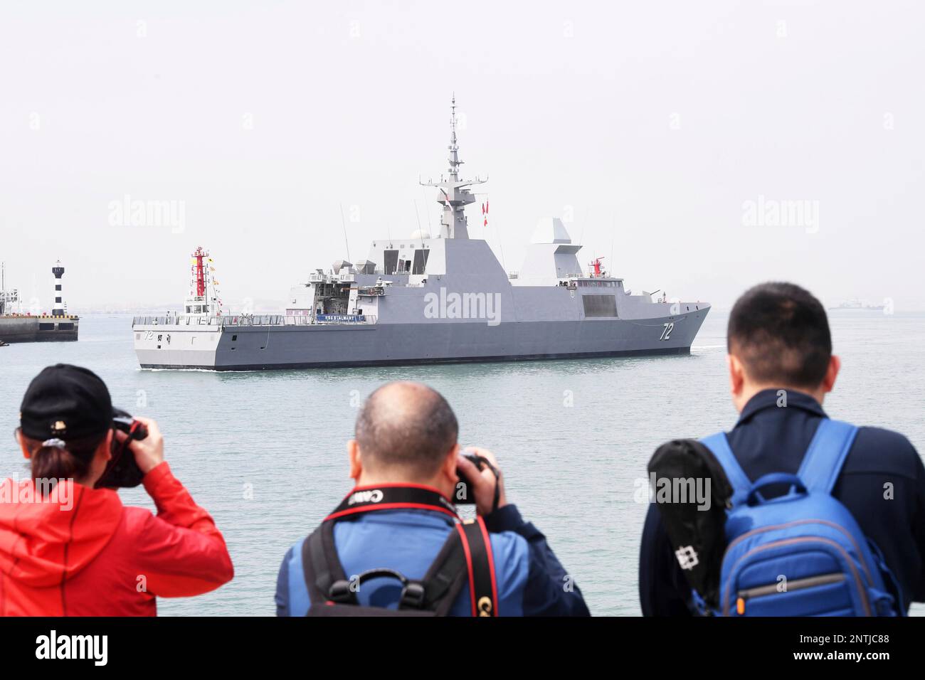 People take photos as the Singapore Navy frigate RSS Stalwart arrives ...
