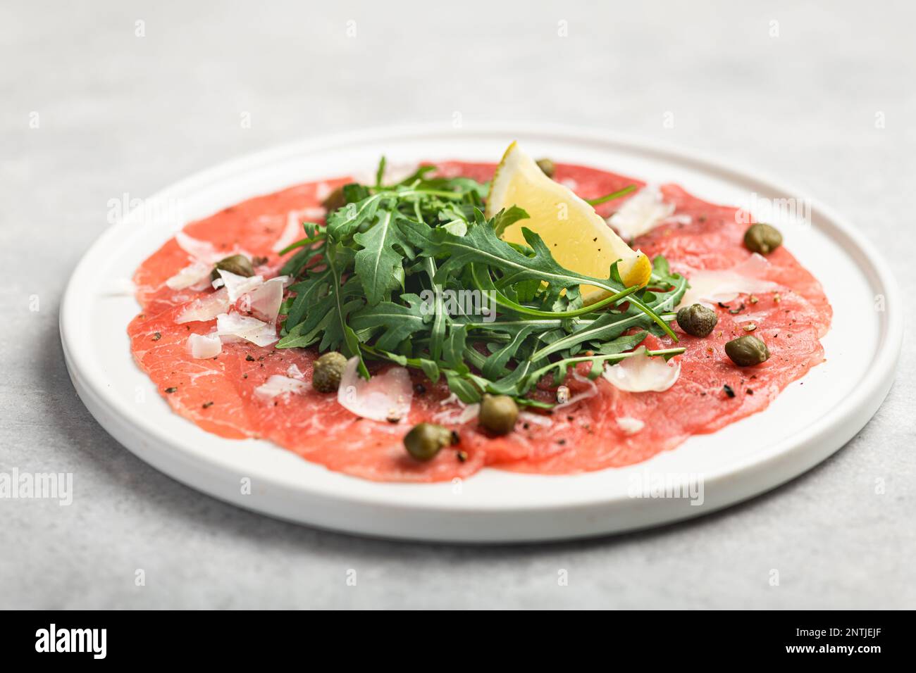 Beef carpaccio with capers, arugula and parmesan Stock Photo - Alamy