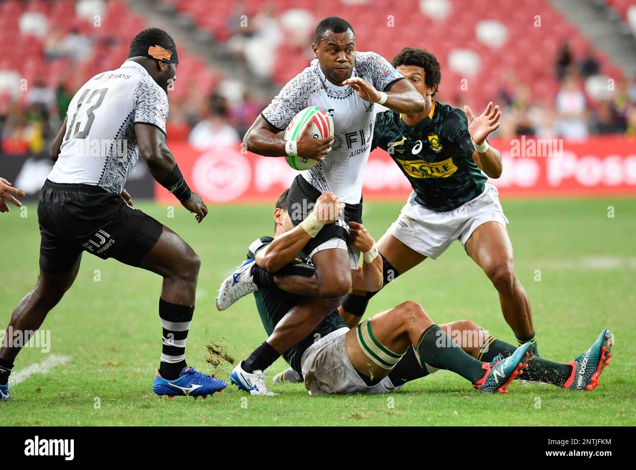 Fiji's Alasio Naduva breaks through South African tackles during the ...