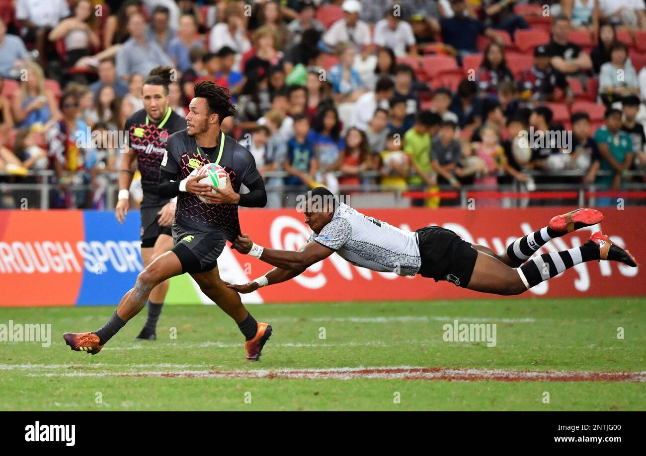 England's Femi Sololarin avoid the diving tackle from Fiji's Sevuloni ...