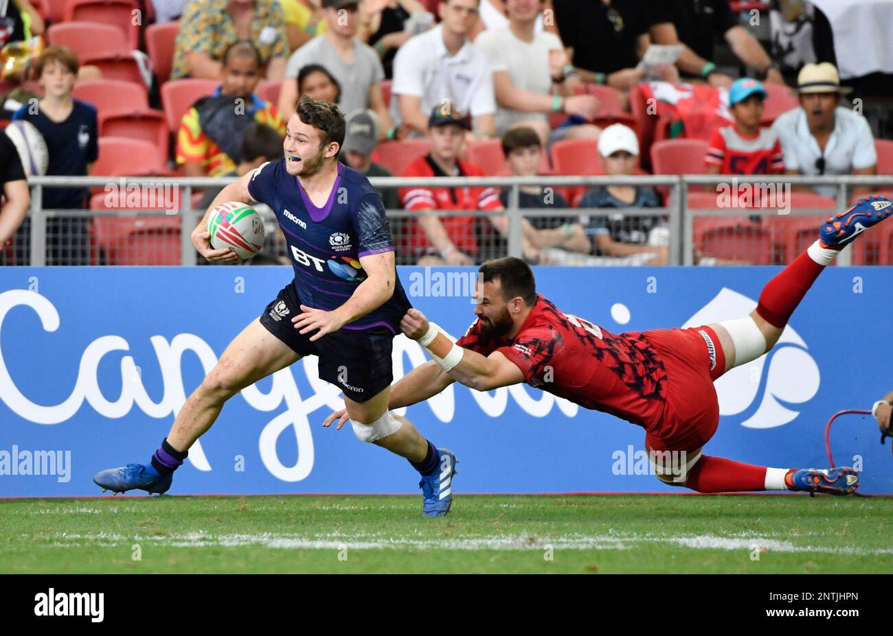 Scotland's Max McFarland escapes the tackle from Wales's Ethan Davies during the HSBC Singapore ...