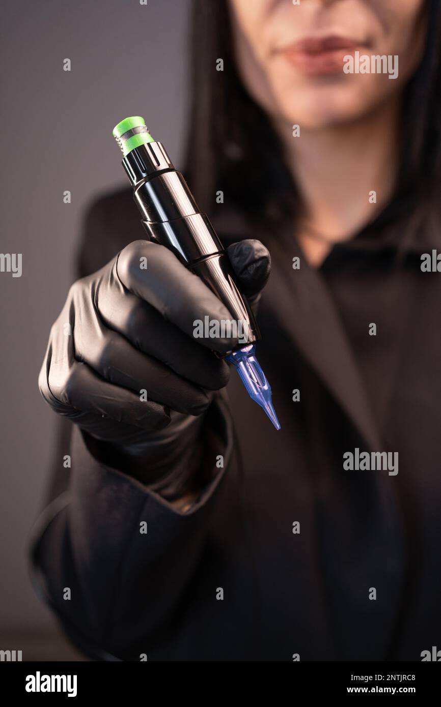 Permanent makeup machines in cosmetologist hand. Hands holding tattoo ...