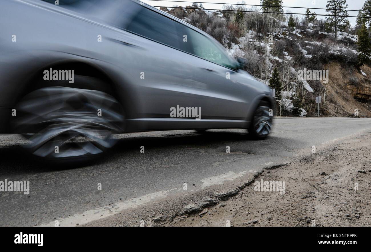 Cars drive over a series of potholes Tuesday, April 9, 2019, leaving ...