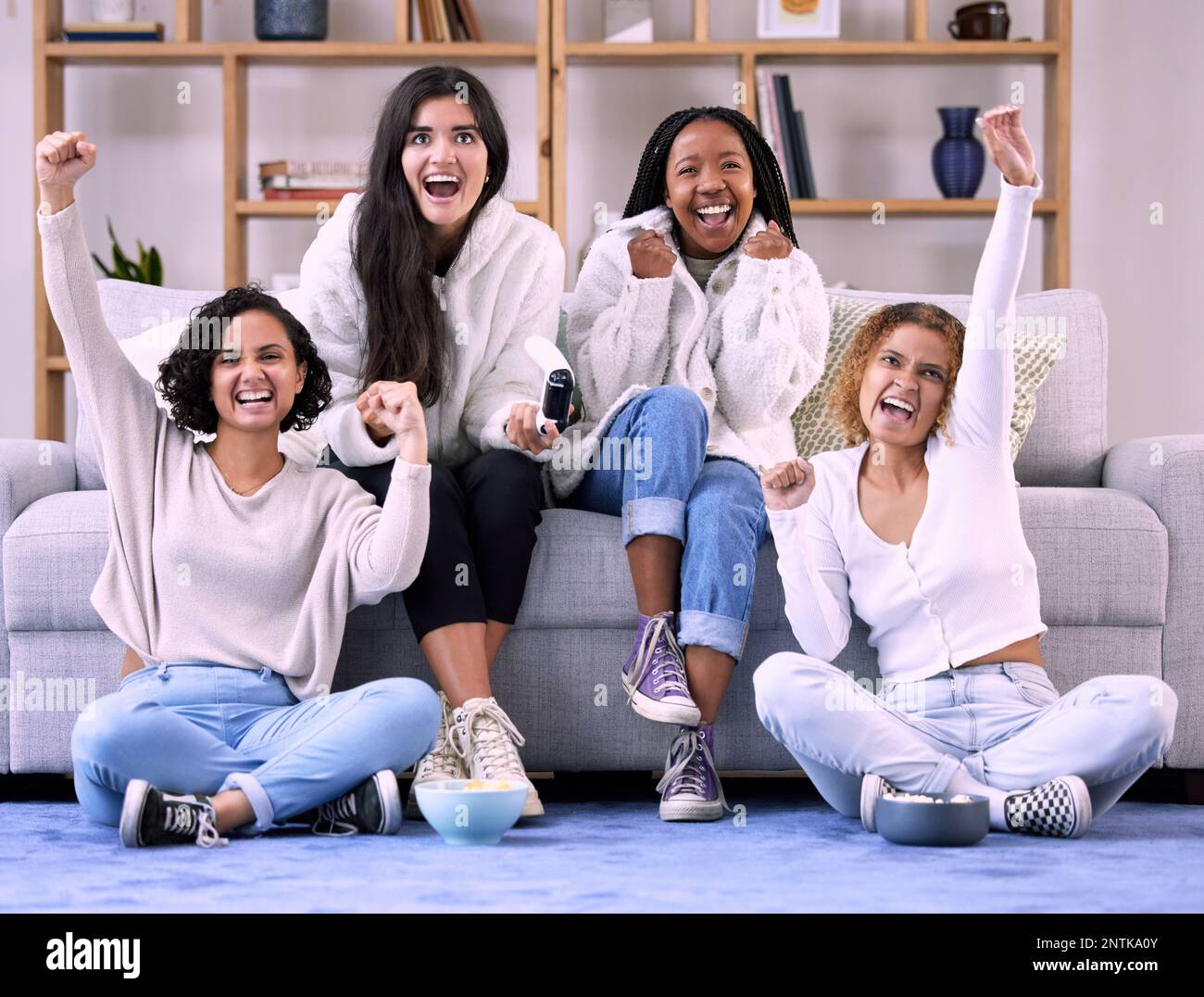 Excited, friends and women in lounge, video game and quality time with ...