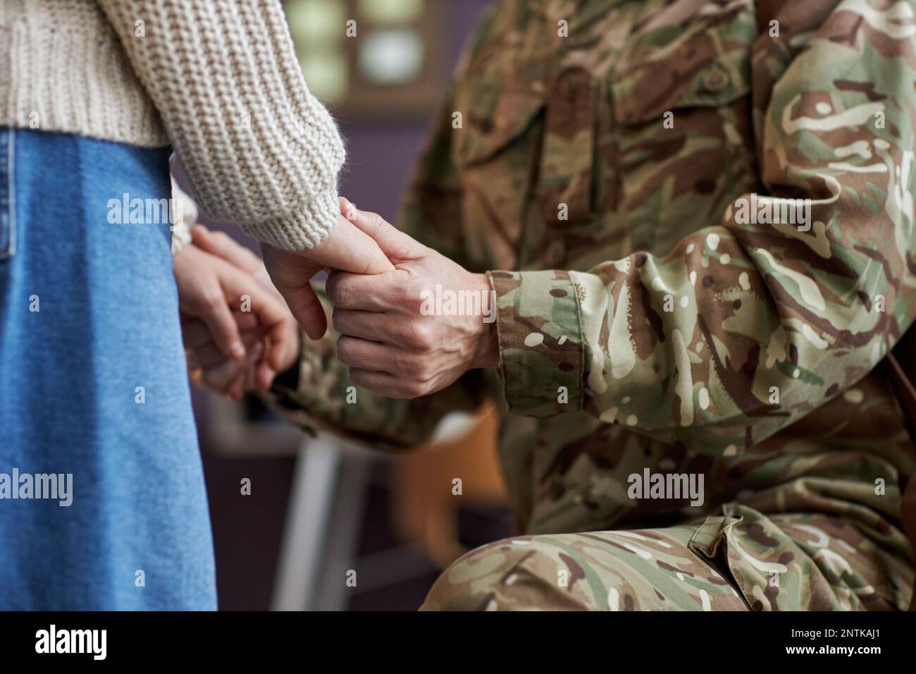 Close up of military dad holding hands with daughter in bonding moment ...