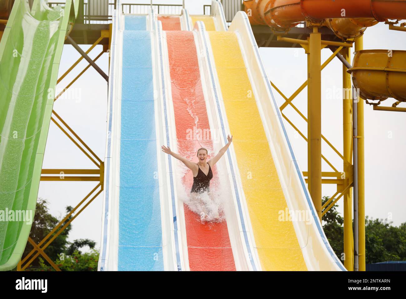 Young woman on slide in water park Stock Photo - Alamy