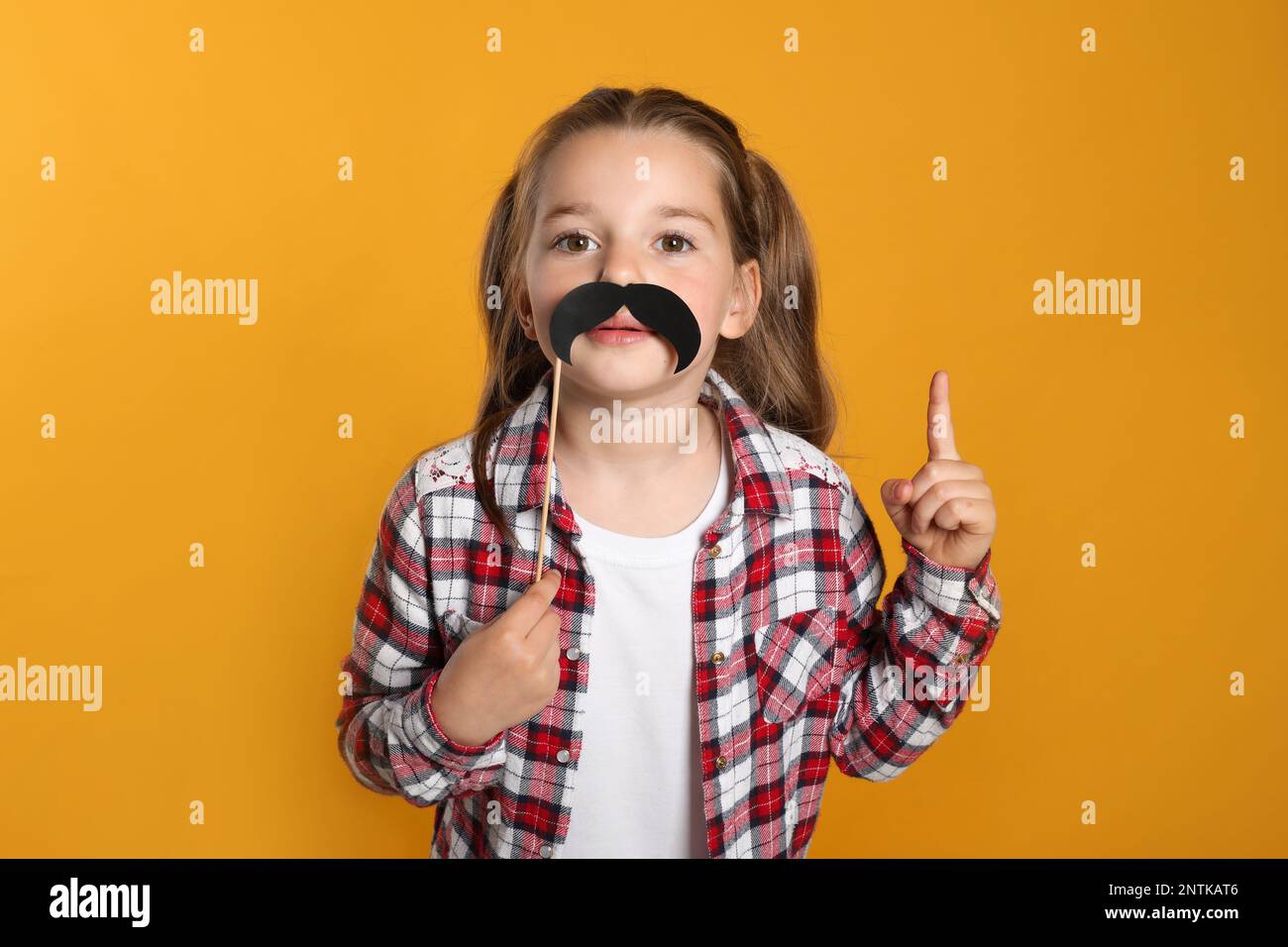 Funny little girl with fake mustache on yellow background Stock Photo ...