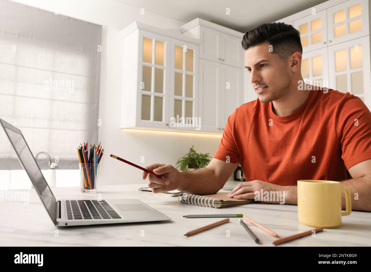 Man drawing in notebook at online lesson indoors. Distance learning ...