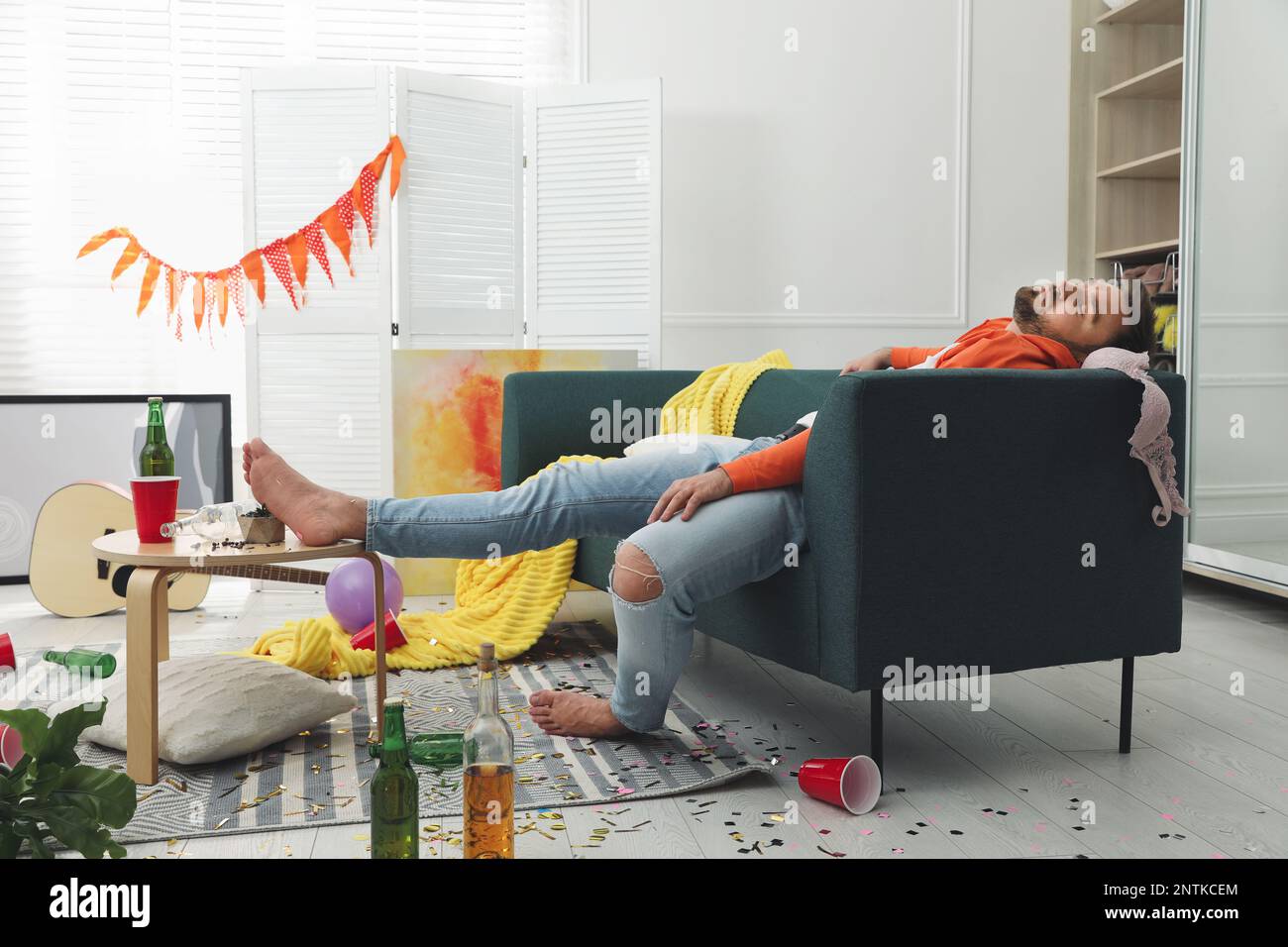 Young man sleeping on sofa in messy room after party Stock Photo - Alamy
