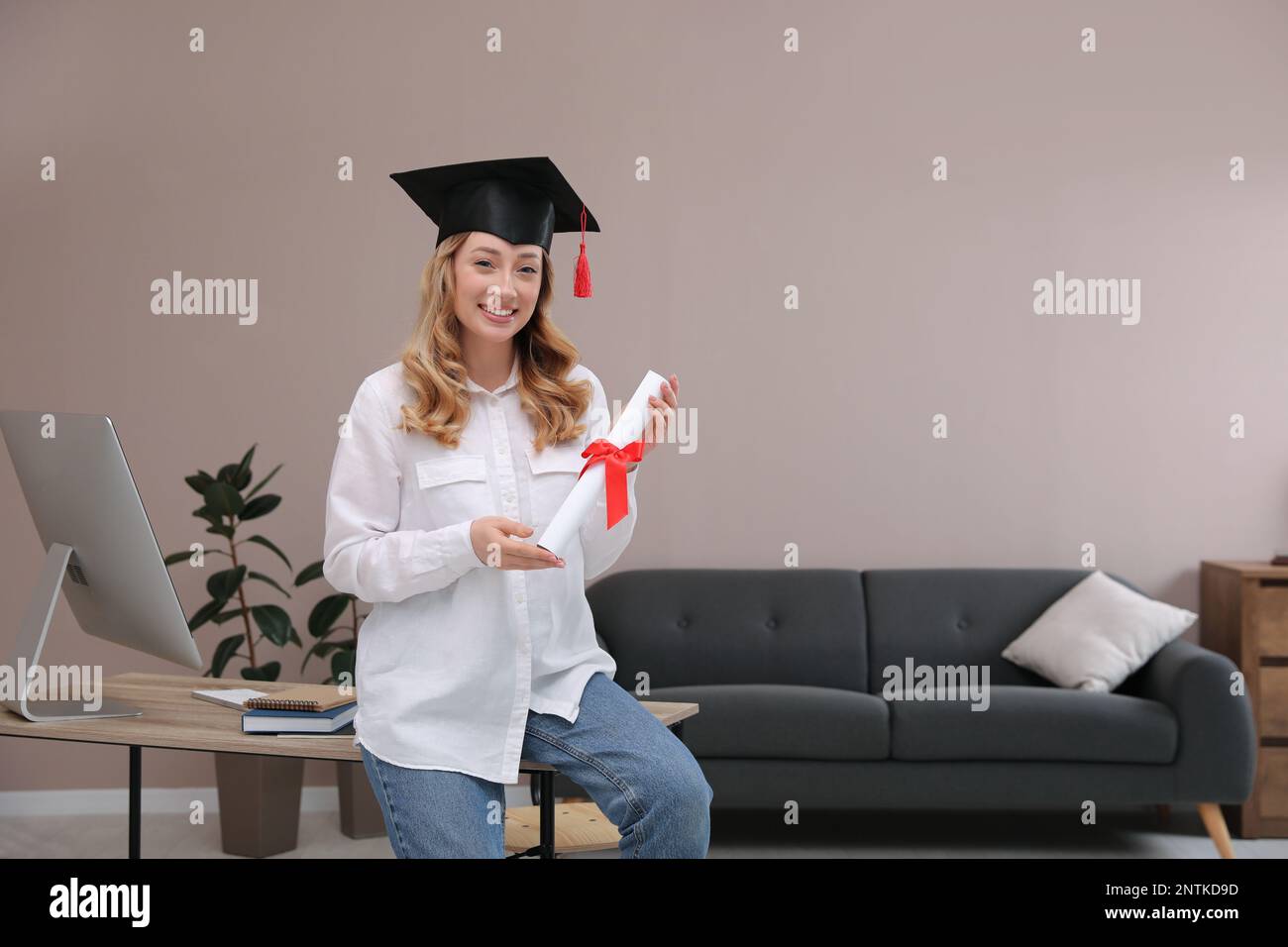 Happy student with graduation hat and diploma at workplace in office ...
