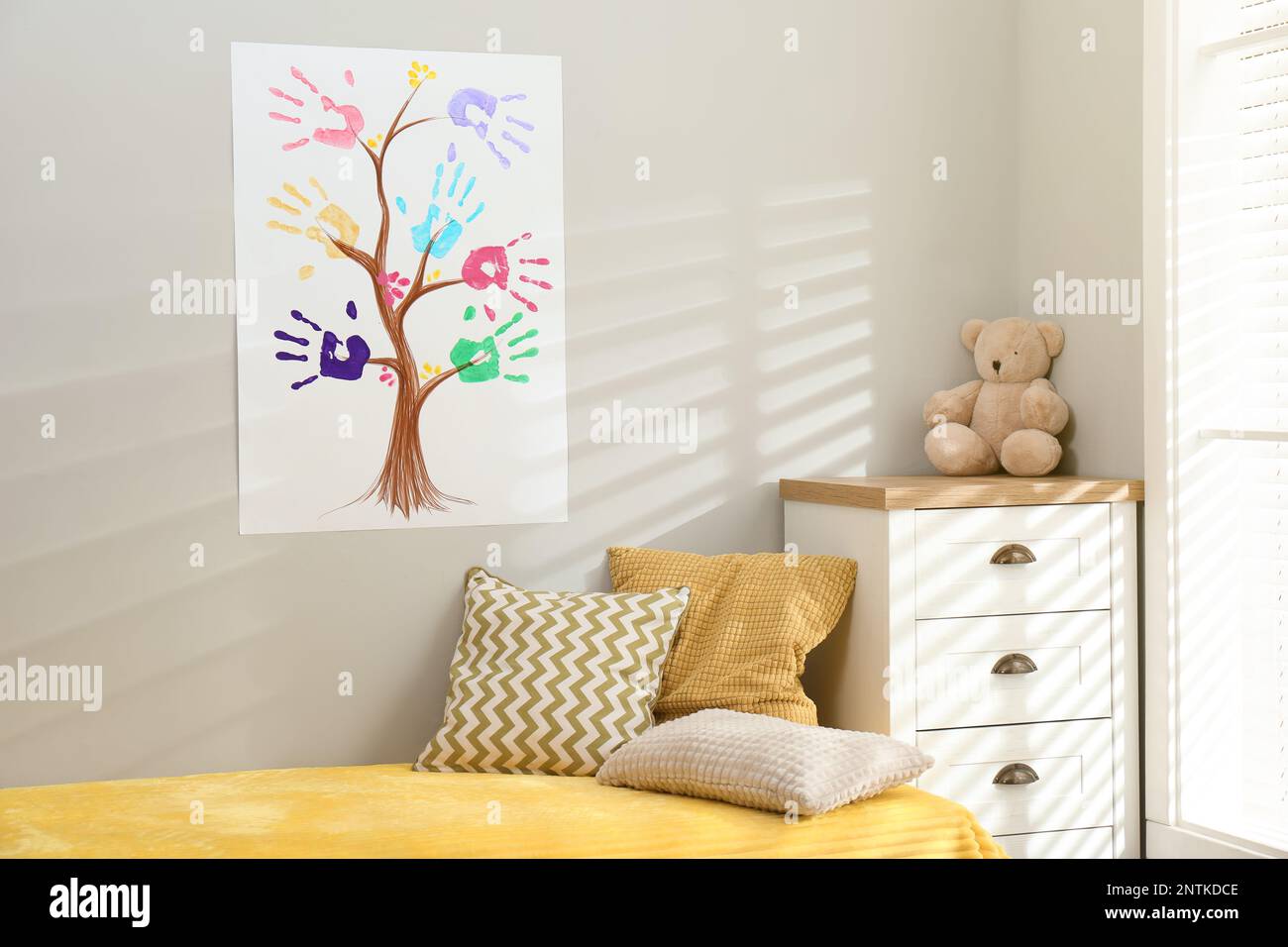 Painting with family tree of colorful palm prints on light wall over ...
