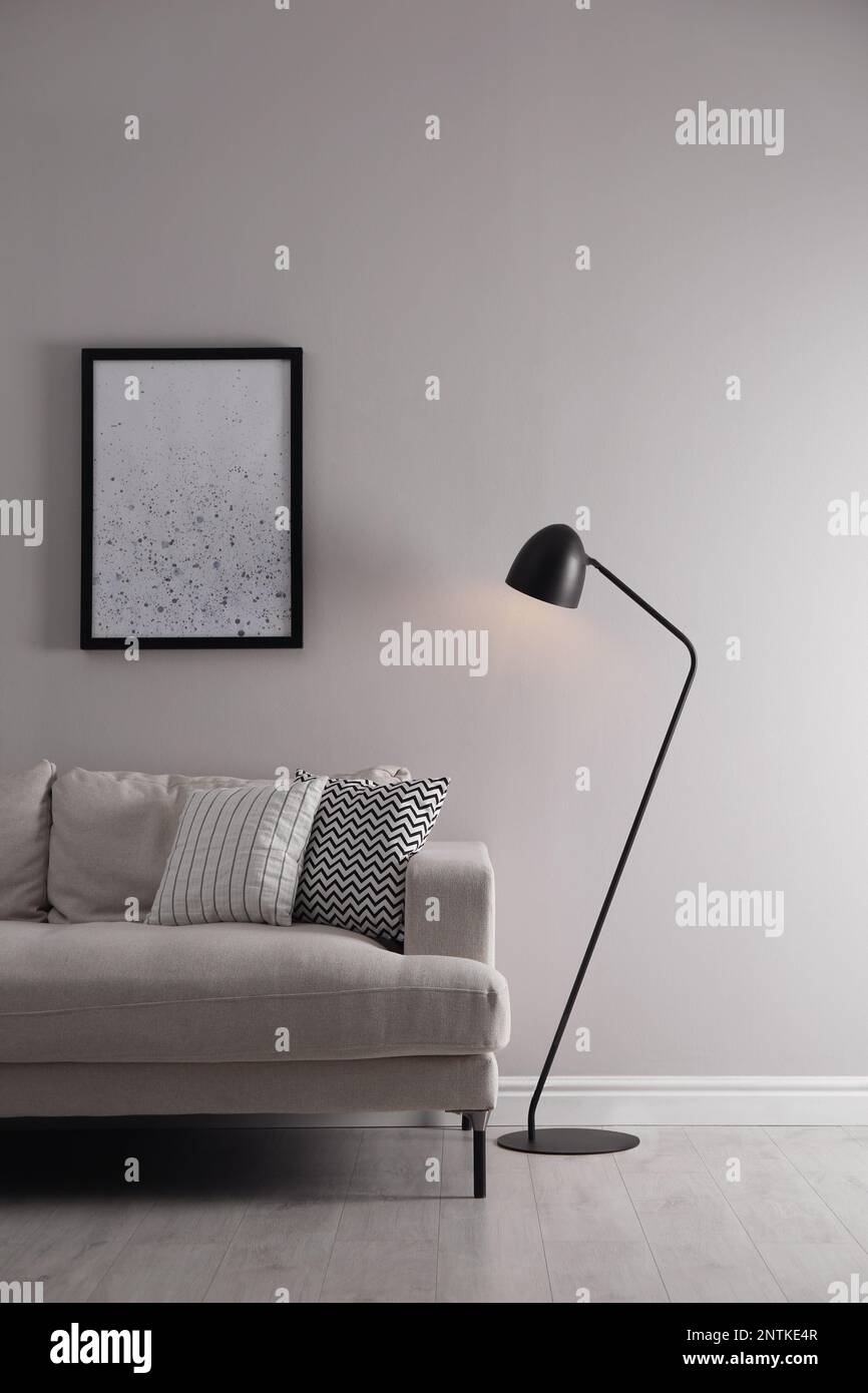 Stylish living room interior with comfortable sofa and floor lamp Stock ...