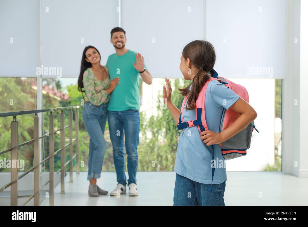 Parents waving goodbye to their daughter in school Stock Photo - Alamy
