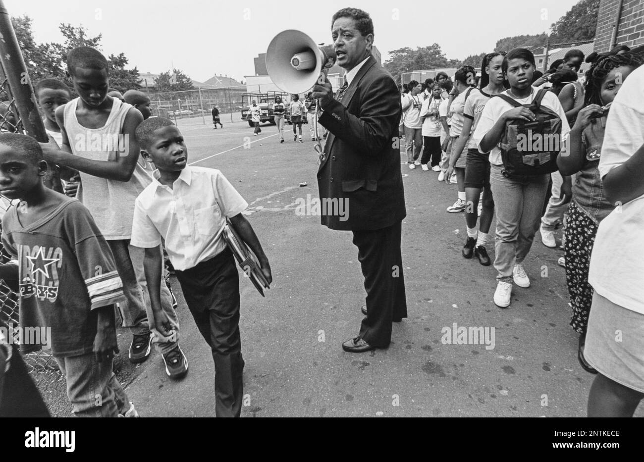 Hine Junior High School principal Bennie Adams gathers the students at the end of recess into a ...