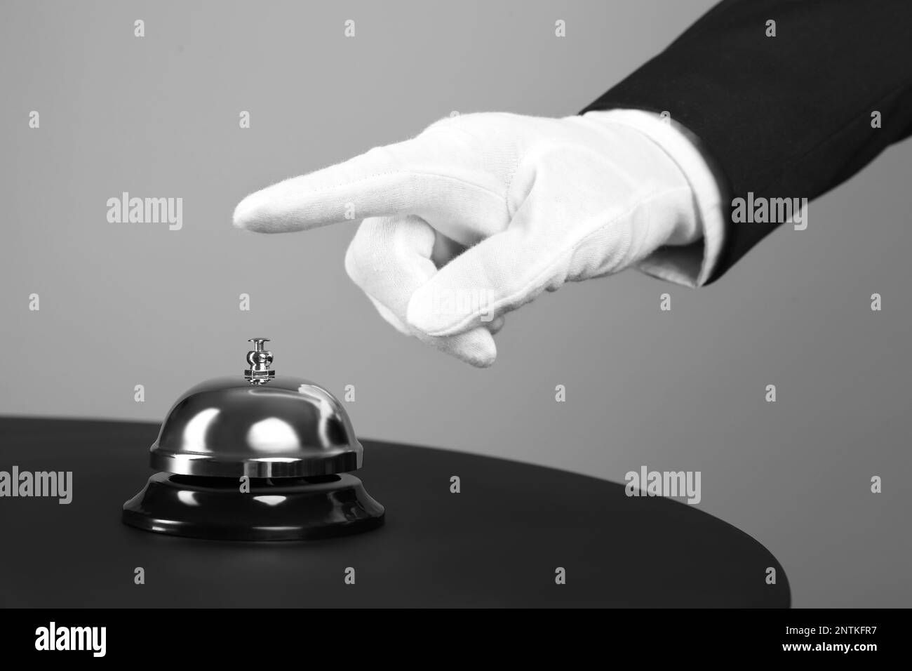 Butler ringing service bell at table, closeup Stock Photo - Alamy