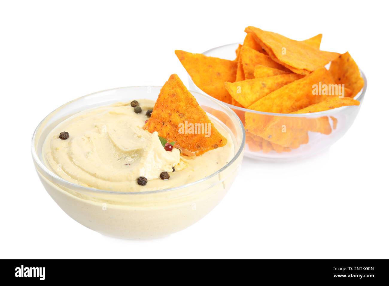 Delicious hummus and nachos in glass bowls on white background Stock ...