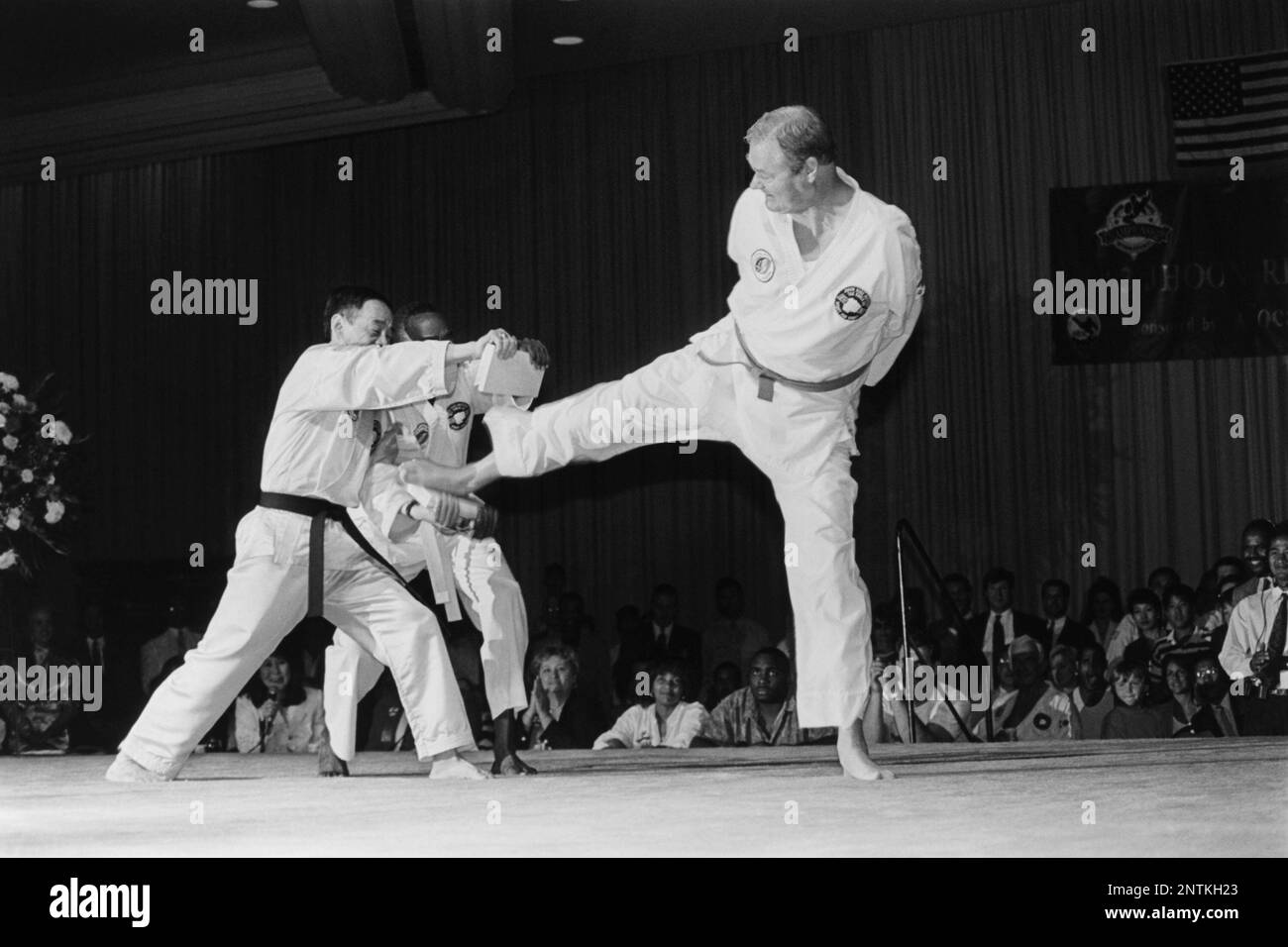 Rep. Ike Skelton, D-Mo., breaks a board held by Jhoon Goo Rhee, with a ...
