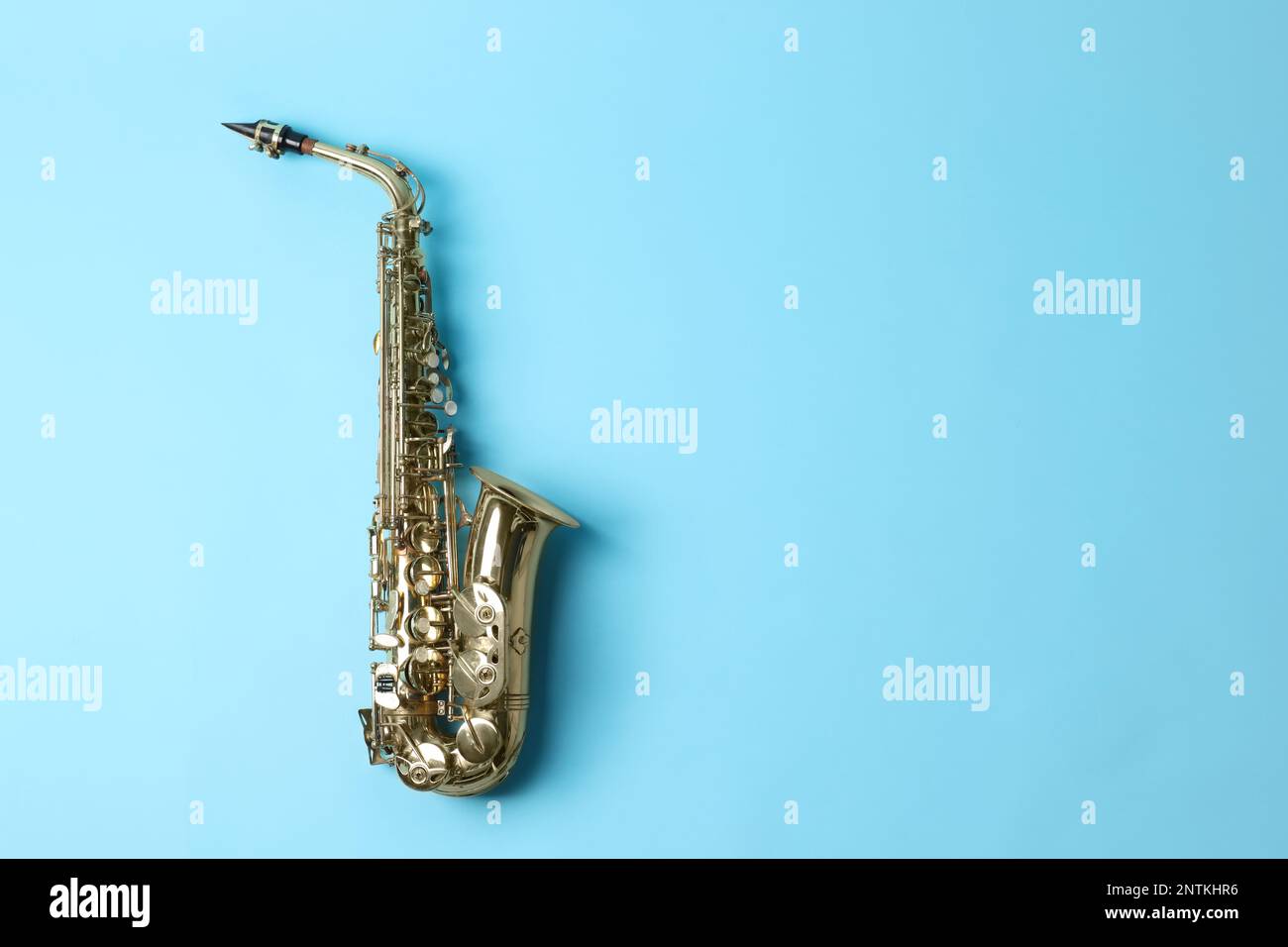 Beautiful saxophone on light blue background, top view. Space for text ...