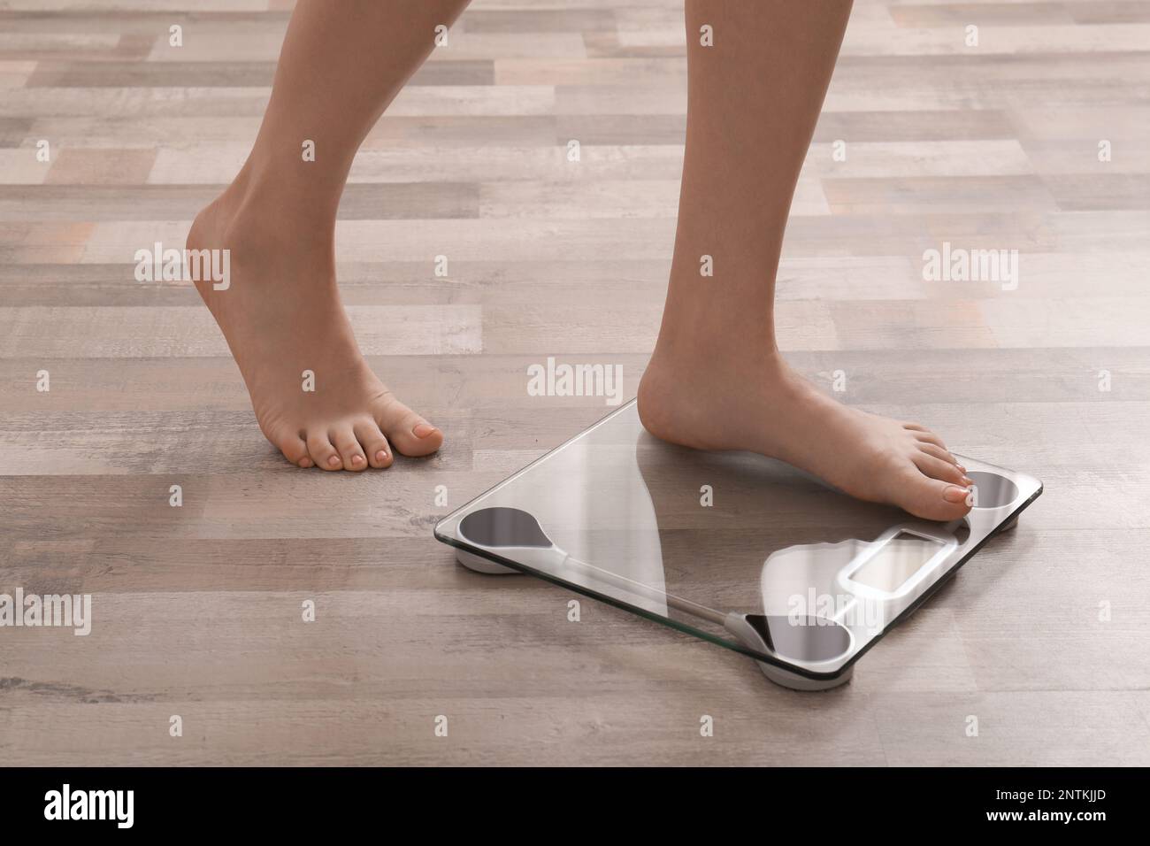Woman stepping on floor scales indoors, closeup. Weight control Stock ...